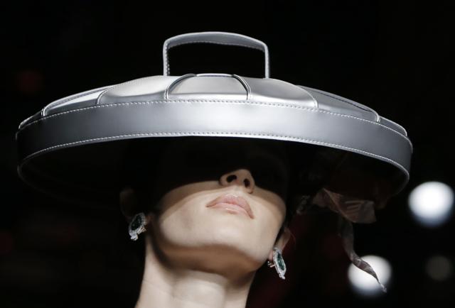 Why Is This Model Wearing A Garbage Can Lid On Her Head?